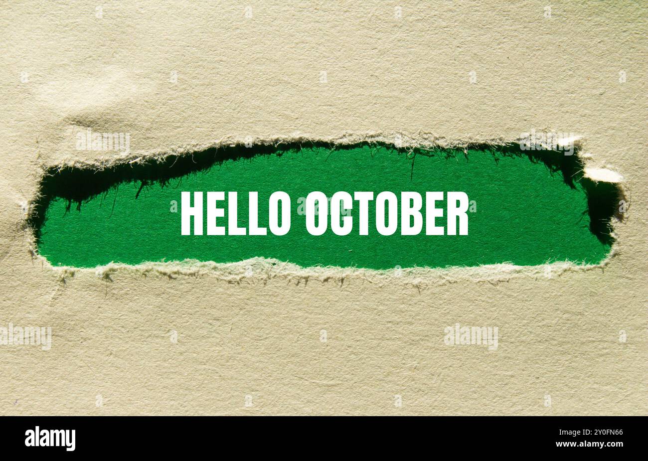 Hello october message written on ripped torn paper with green ...