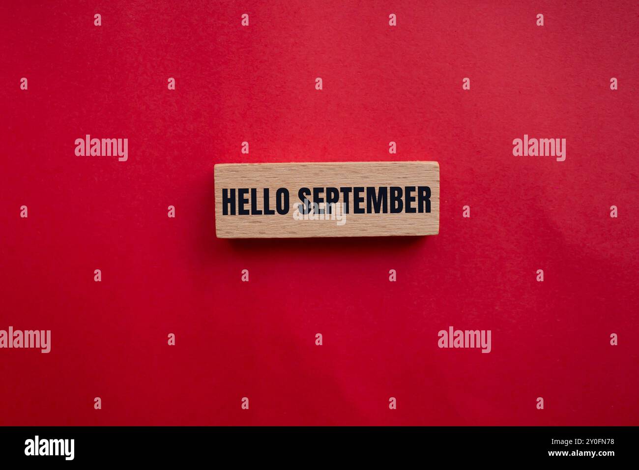 Hello september message written on wooden block with redbackground ...