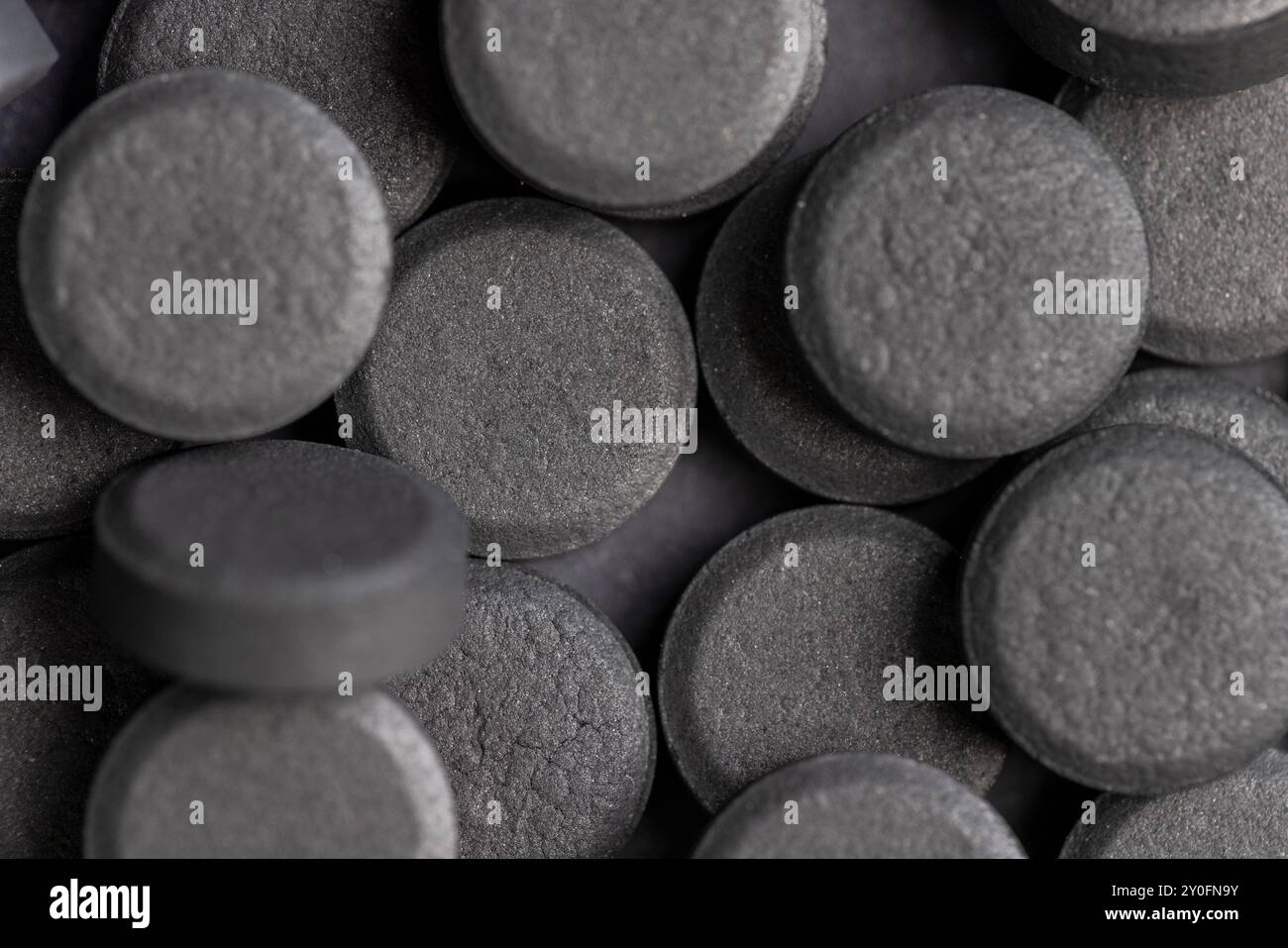Open and unpacked tablets of black color close-up, several of the same ...