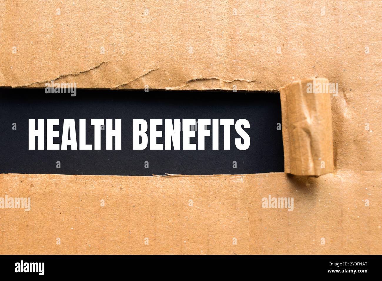 Health benefits message written on ripped torn cardboard paper with ...
