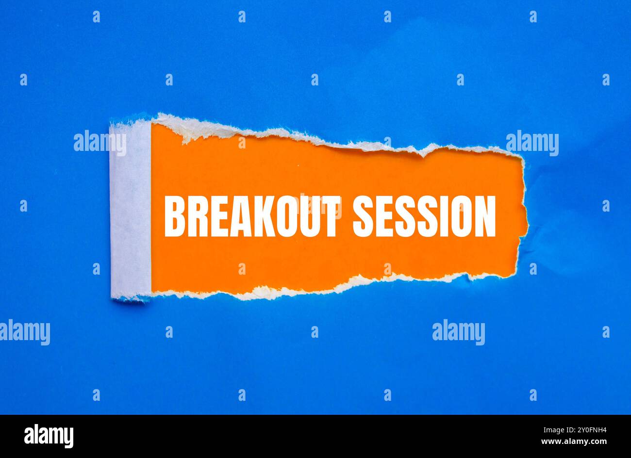 Breakout session message written on ripped torn blue paper with orange ...