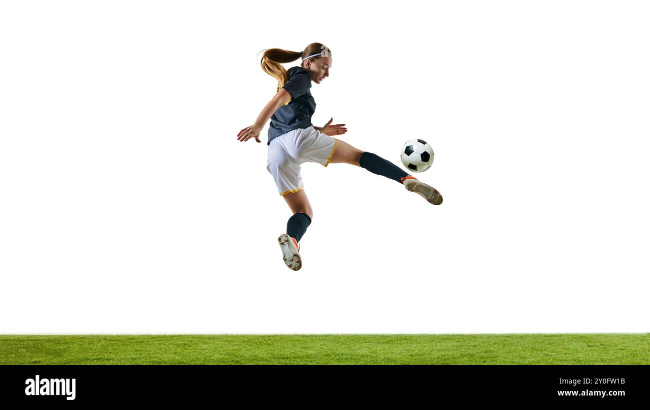 determined female soccer player, mid-20s, airborne, performing ...