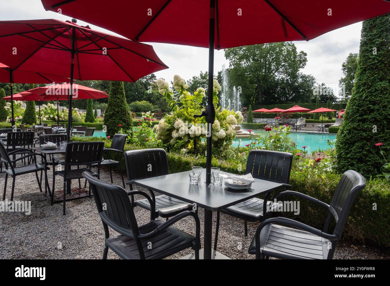 Patio table with a red umbrella located next to a beautiful garden with ...