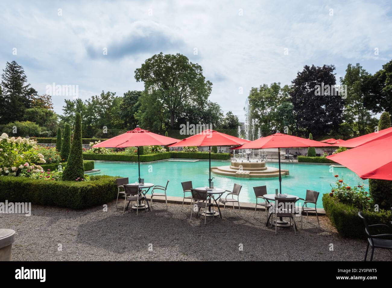 Patio table with a red umbrella located next to a beautiful garden with ...