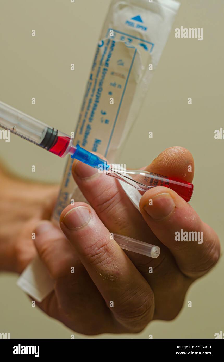 male hands draw medicine from ampoule with a syringe . High quality ...