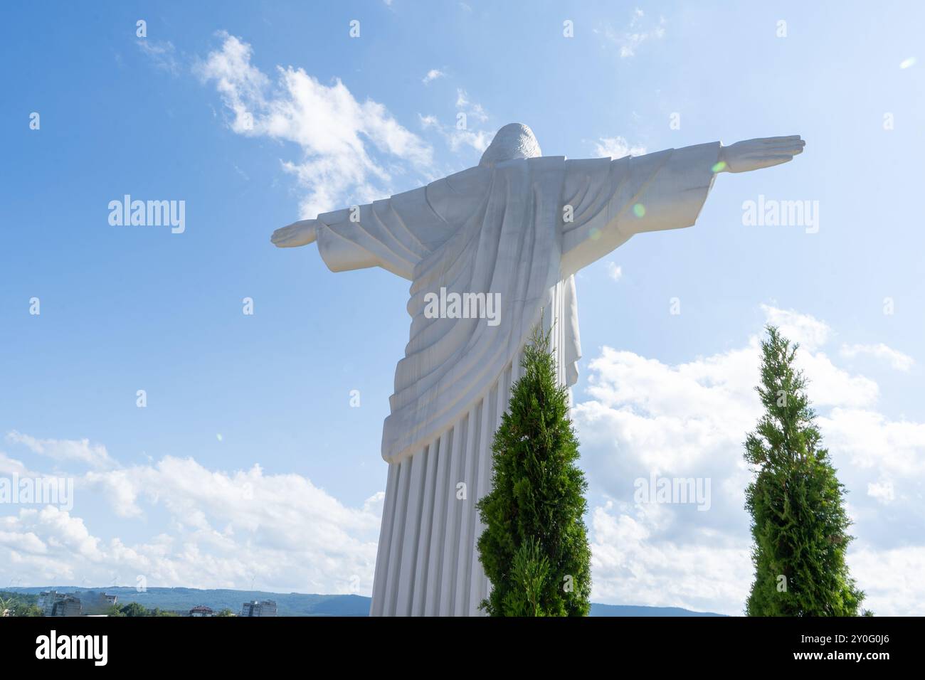 Statue of Jesus Christ against the blue sky. View from the back ...