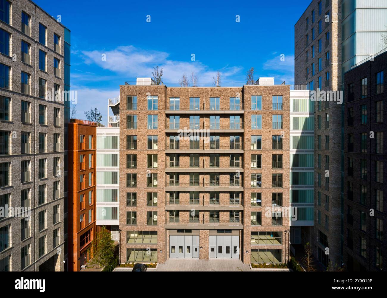 Front elevation of sunlit apartment block. Osier Way, London, United ...