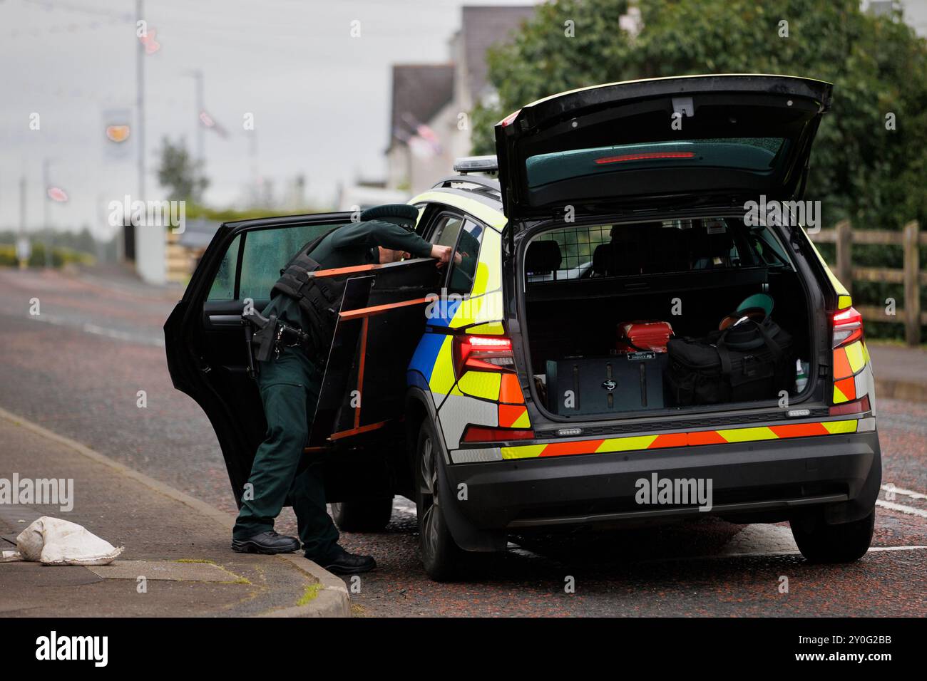 PSNI officer removing a road sign with image of people a dingy boat ...