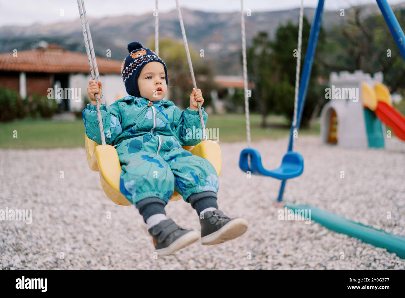 Little girl swings on a rope swing on the playground Stock Photo - Alamy