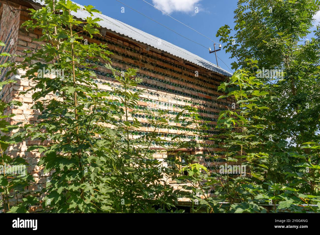 The wall of the house is made of bricks and glass green bottles ...