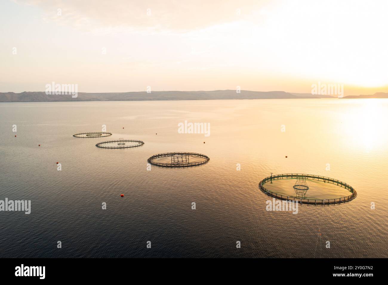 The tranquil waters of a lake host a circular fish farming facility ...