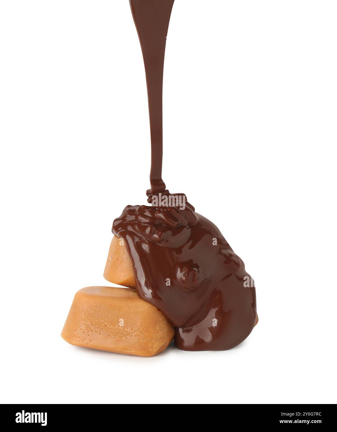 Pouring delicious melted chocolate onto caramel candies isolated on ...
