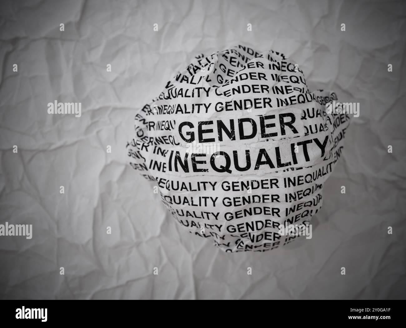 Crumpled paper ball with words Gender Inequality on a torn white paper ...