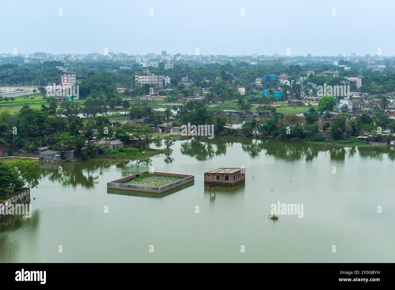 Aerial view of green cityscape with large lake, buildings surrounded by ...