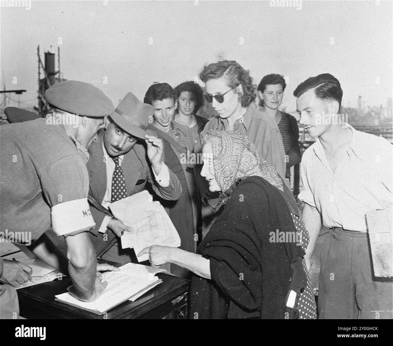 Jewish displaced persons in Naples fill out papers in the presence of ...