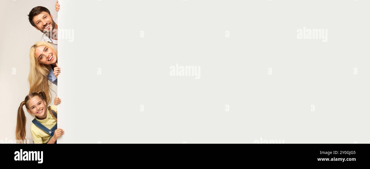 Happy Family Three Playfully Peeking Around a Blank Wall Stock Photo ...