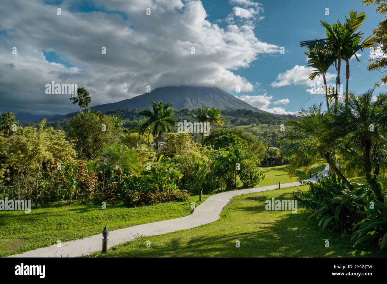 Path leading across green grass tropical gardens Arenal Volcano Costa ...