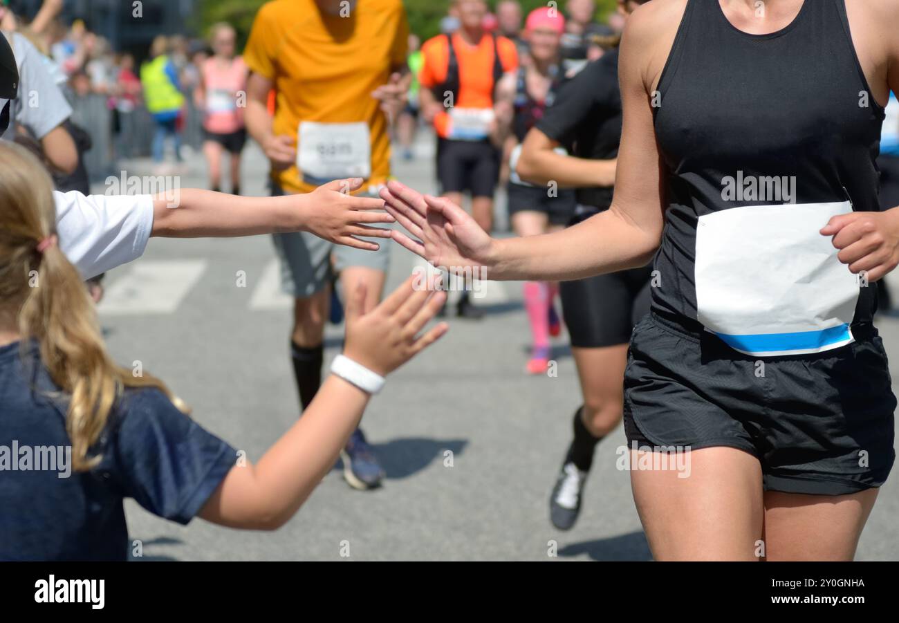 Marathon running race,runners support on road race, child's hand giving ...