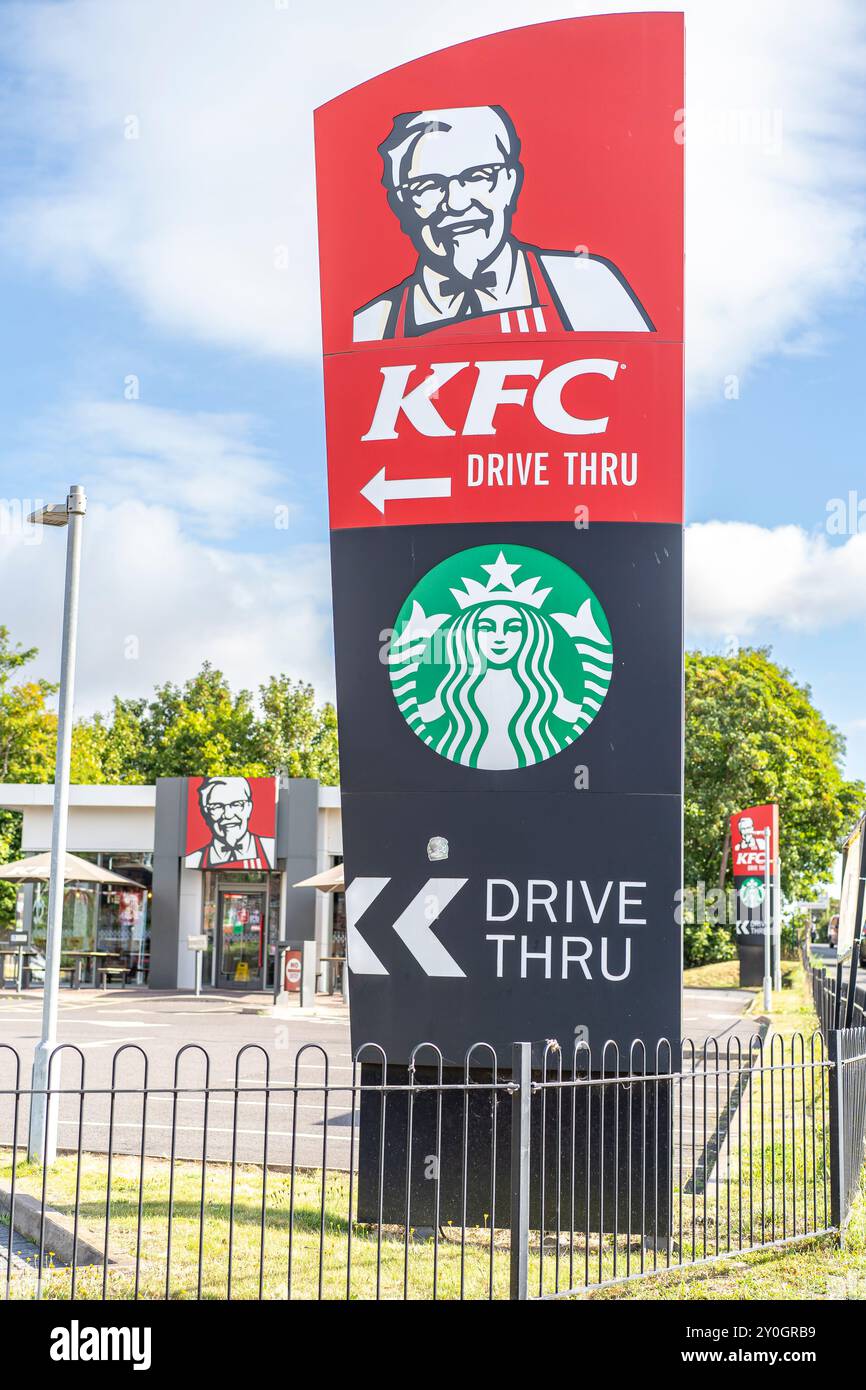 Signage for a KFC and Starbucks drive thru restaurant on a bright sunny ...