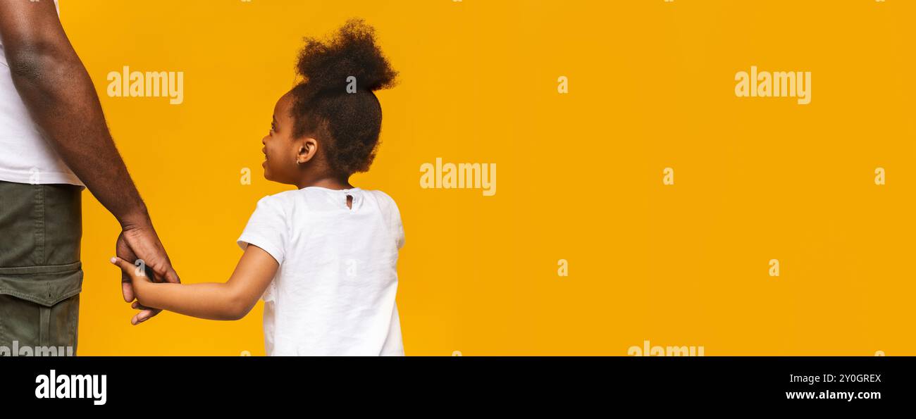 Parent And Child Walking Hand In Hand Against Yellow Background Stock ...