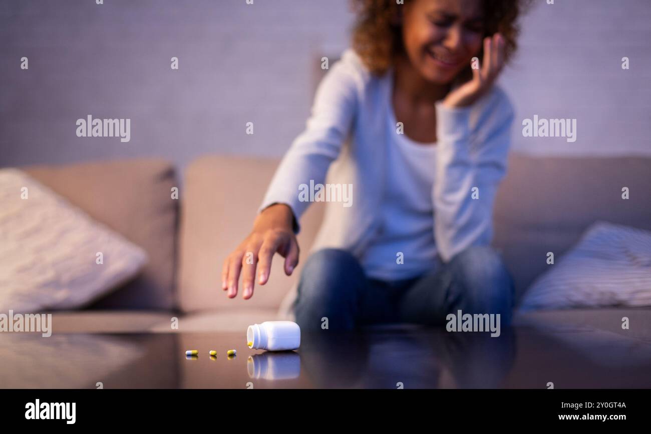 Depression. Crying afro woman taking antidepressant pills Stock Photo ...