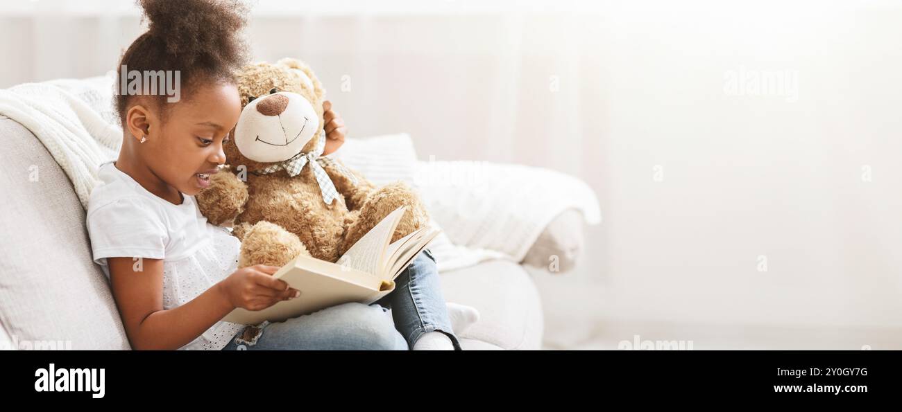 Little Girl Reading Book With Her Teddy Bear at Home Stock Photo - Alamy
