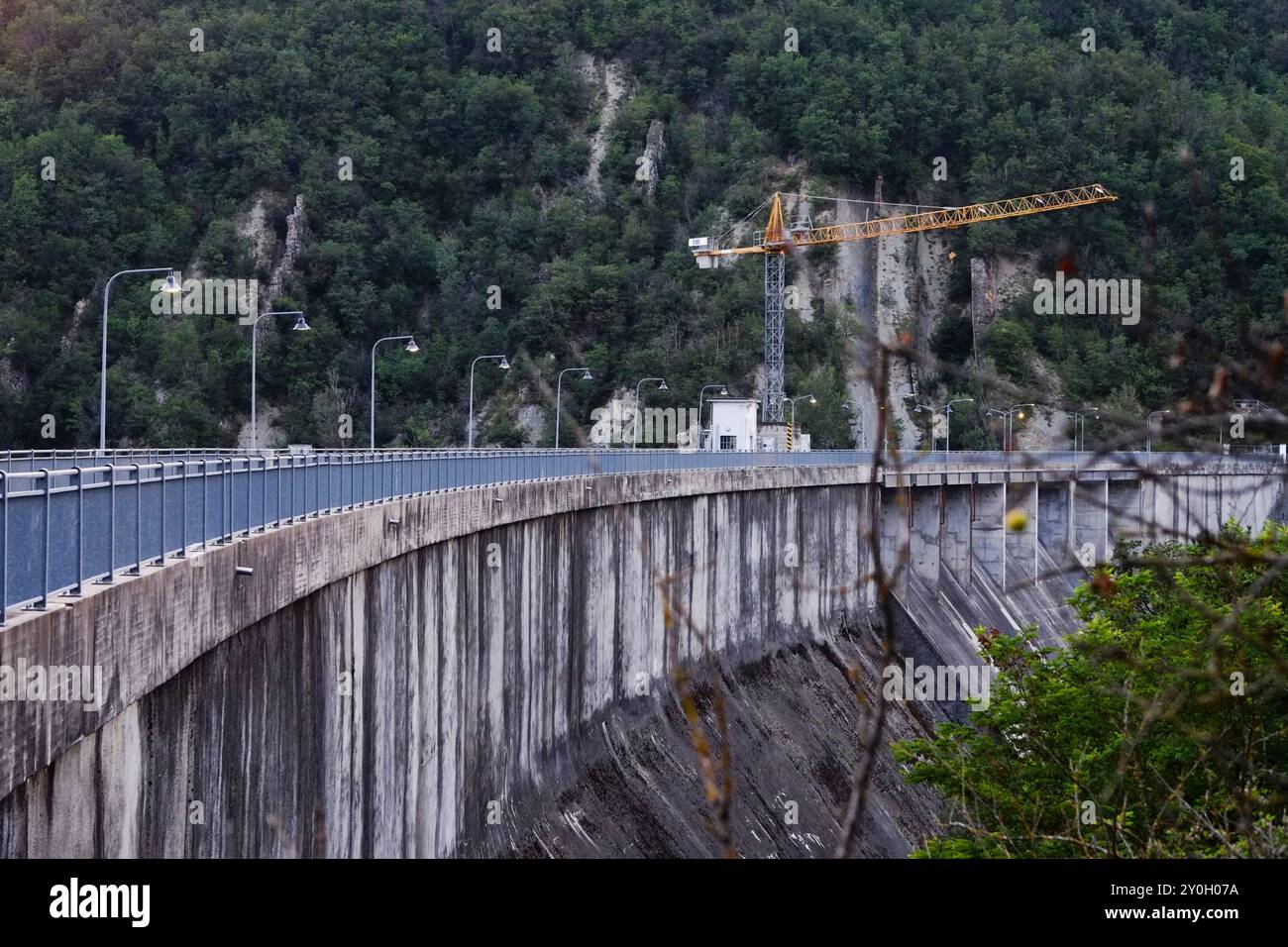 Construction workers building a dam in a mountain forest, using a ...