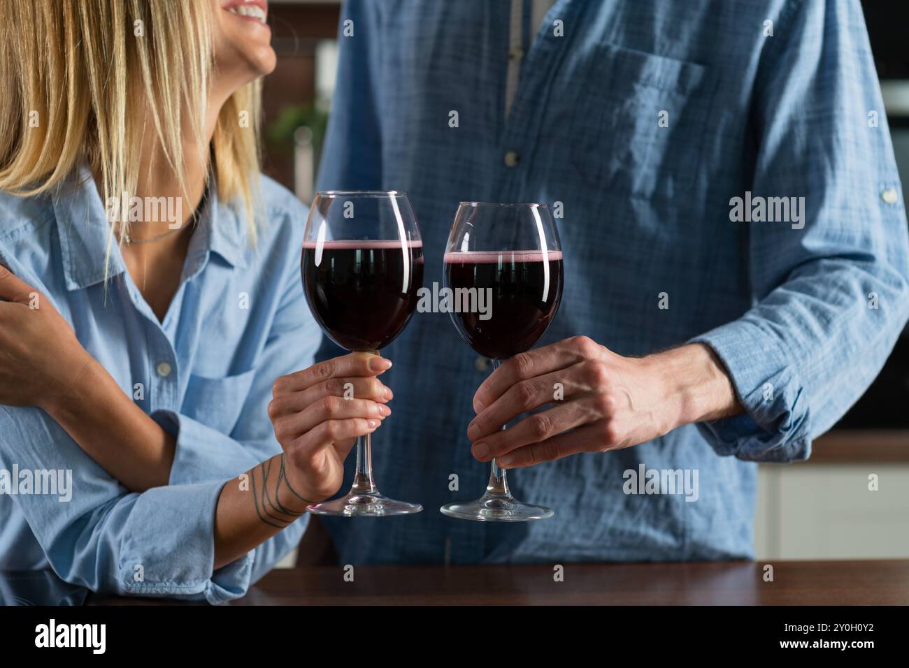Close-up happy couple having fun and toasting standing on a kitchen ...