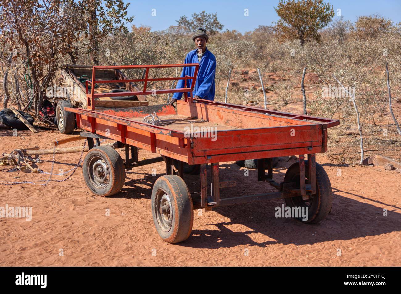 Village african Motswana man in the yard in the back of his donkey cart ...