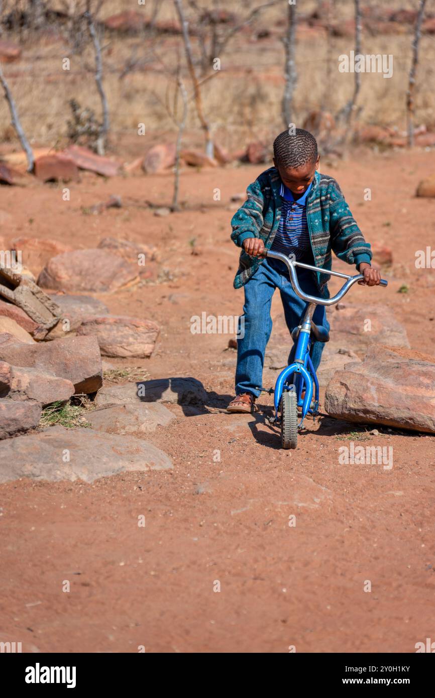 village small african child riding a bike in the sand Stock Photo - Alamy