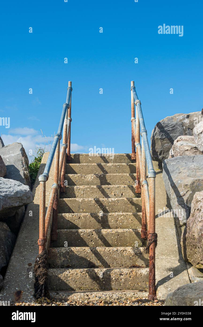 concrete steps with rusty metal handrail, blue sky background Stock ...