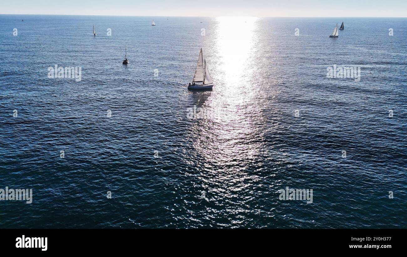 Sailboats are sailing on blue ocean with sun reflection on water Stock ...