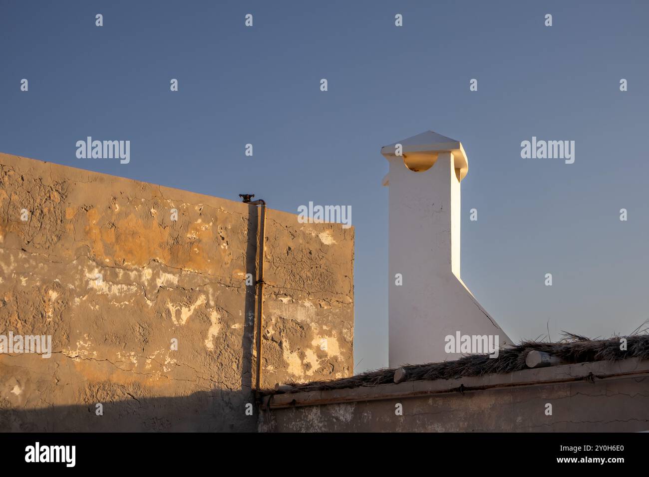 Rooftop with a white chimney. Atmosphere of the golden hour, with and ...