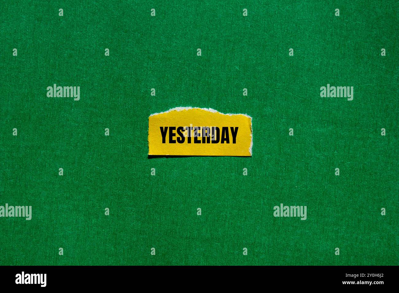 Yesterday message written on ripped torn yellow paper piece with green ...