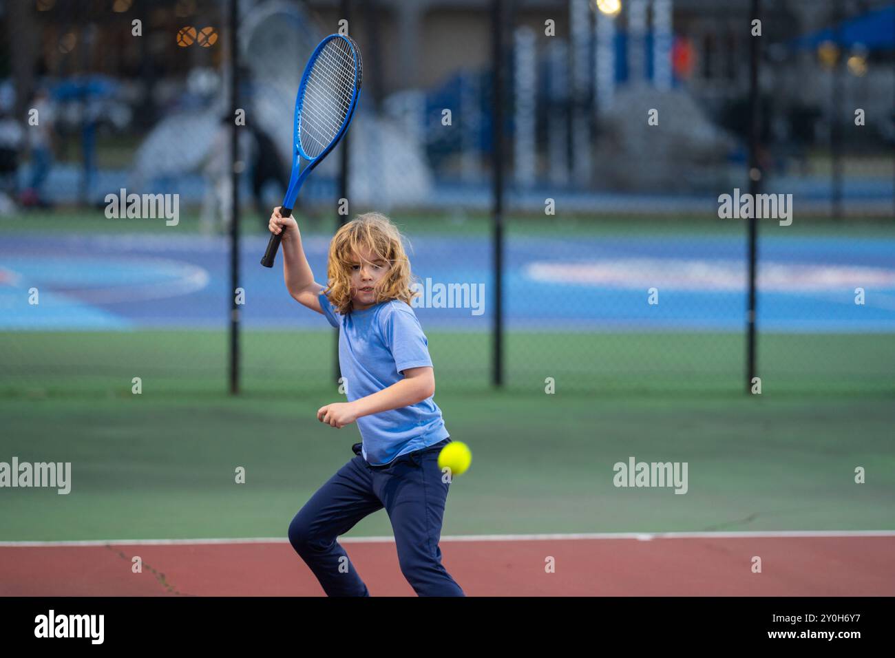 Cute Kid play tennis. Little kid hit tennis ball with tennis racket ...