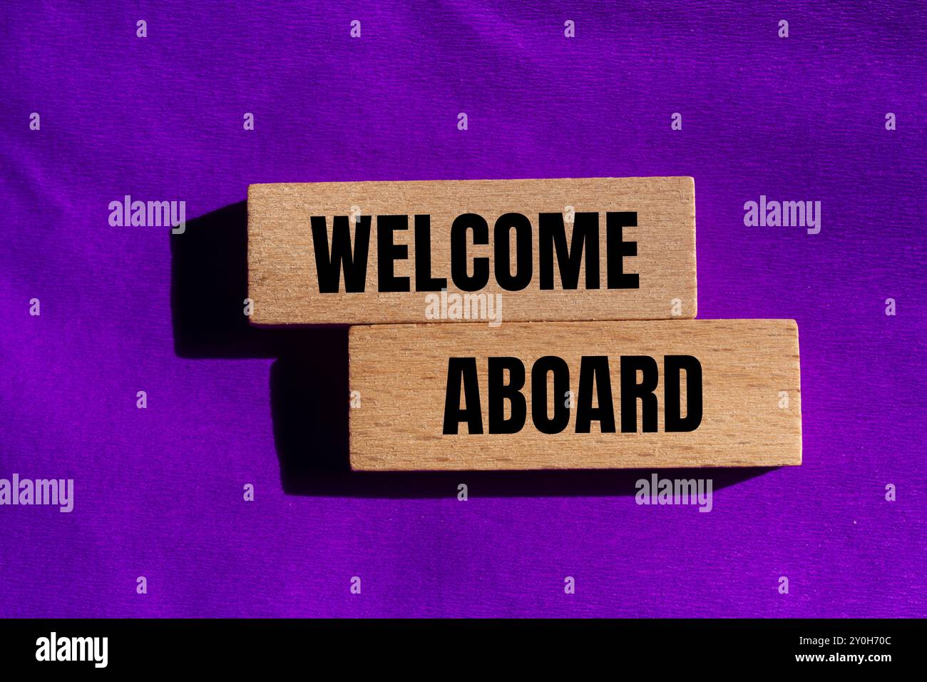 Welcome aboard message written on wooden blocks with purple background ...