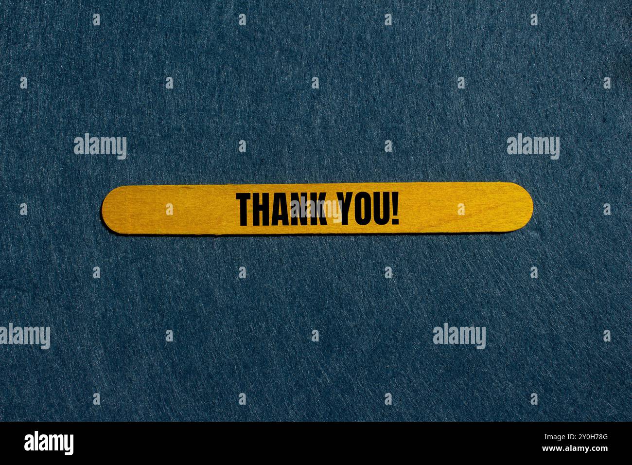 Thank you message written on yellow wooden stick with gray background ...