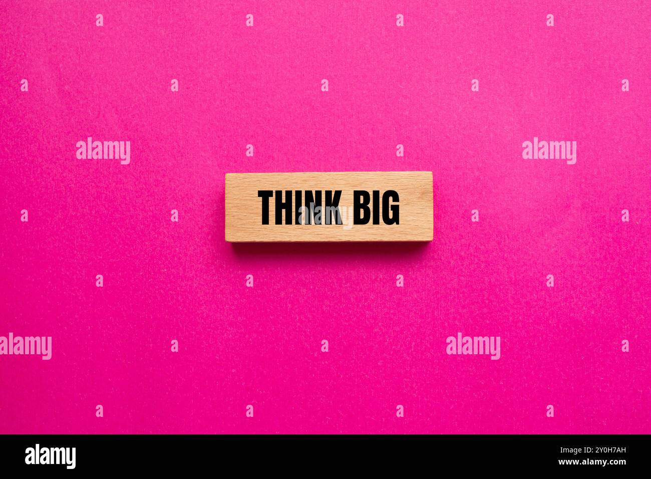 Think big message written on wooden block with pink background ...