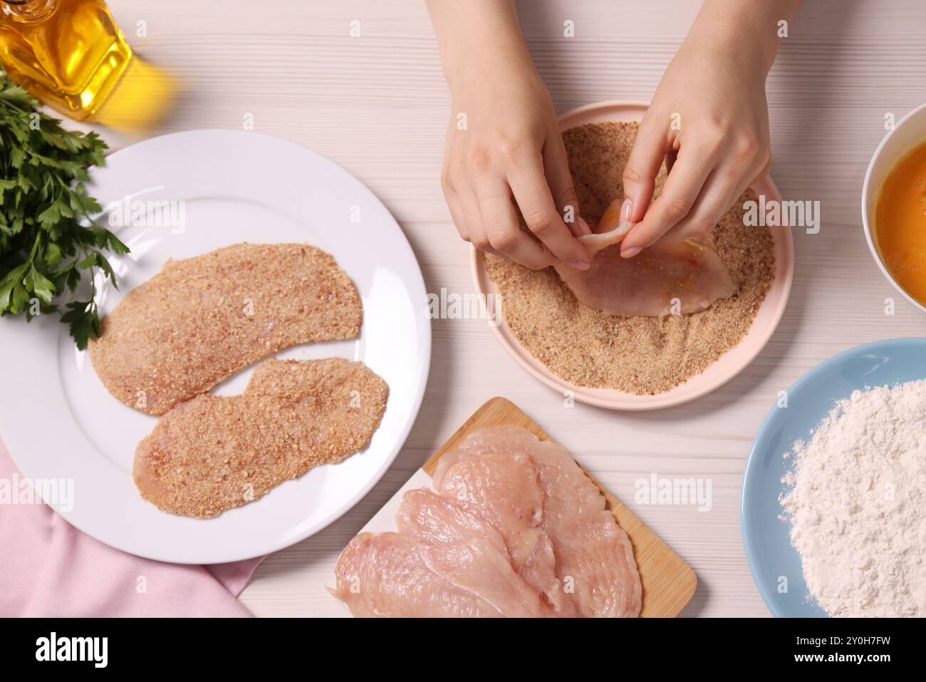 Making schnitzel. Woman coating slice of meat with bread crumbs at ...