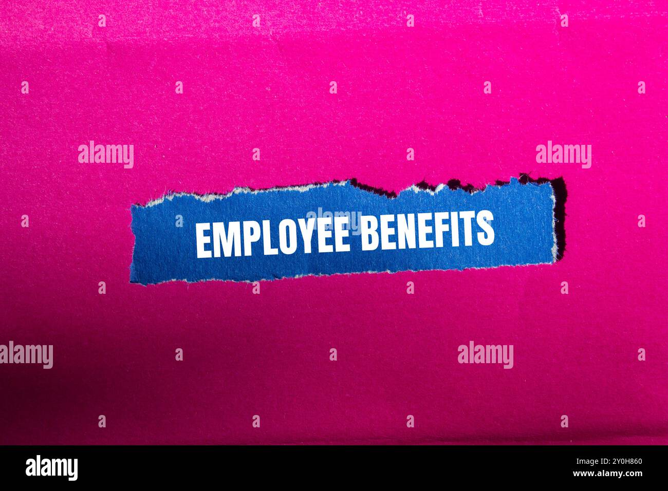 Employee benefits message written on ripped torn blue paper piece with ...