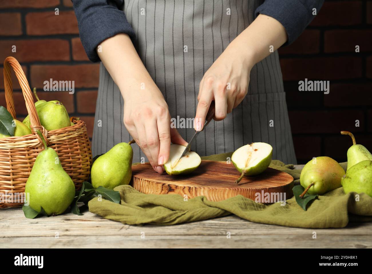 Woman cutting fresh green pears at wooden table, closeup Stock Photo ...