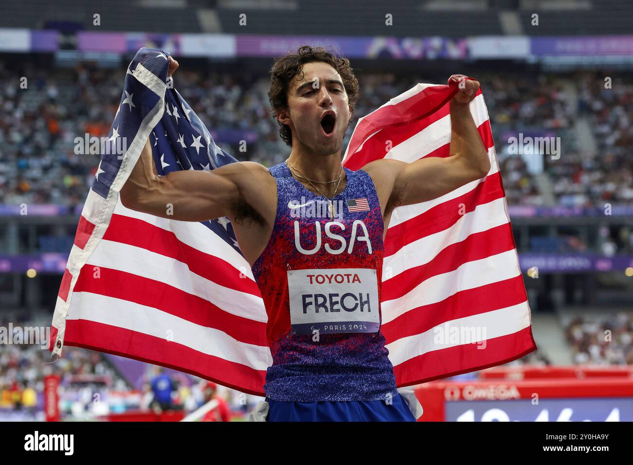 United States' Ezra Frech lifts the American flag after winning the T63 ...