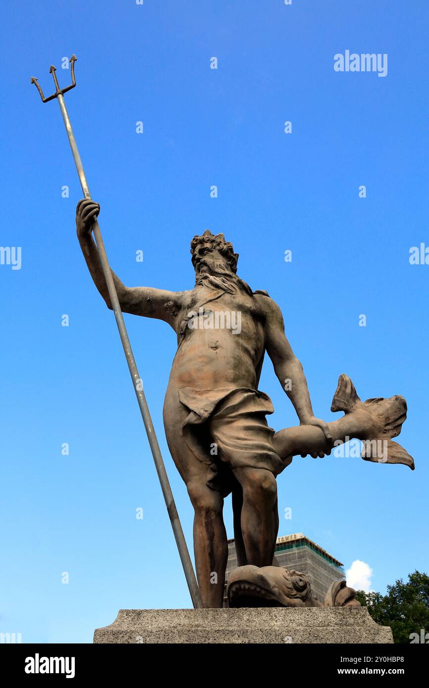 Statue of Neptune (Poseidon) god of the sea with trident, against blue ...