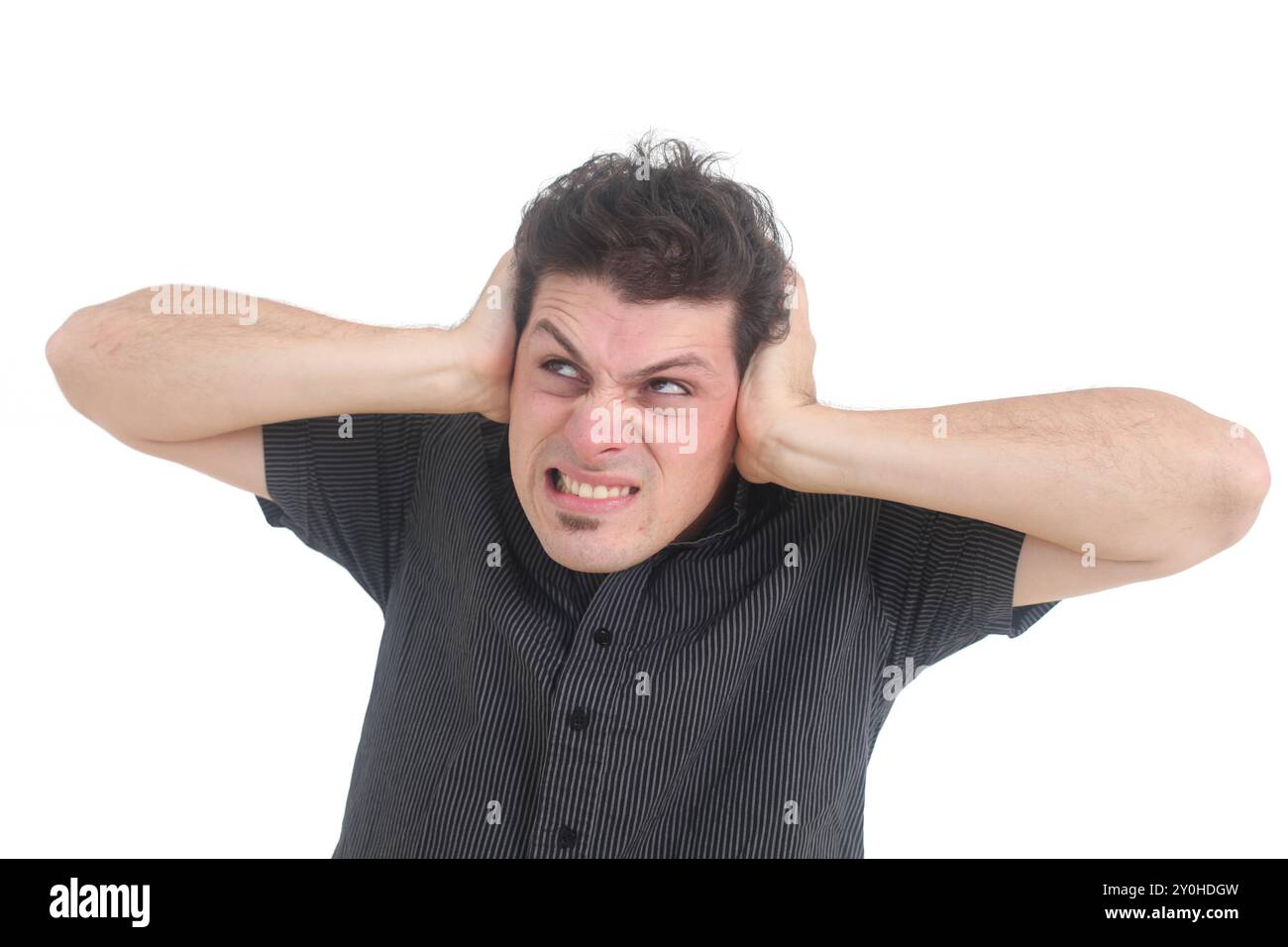 Frustrated and stressed young man holding head in hands while standing ...