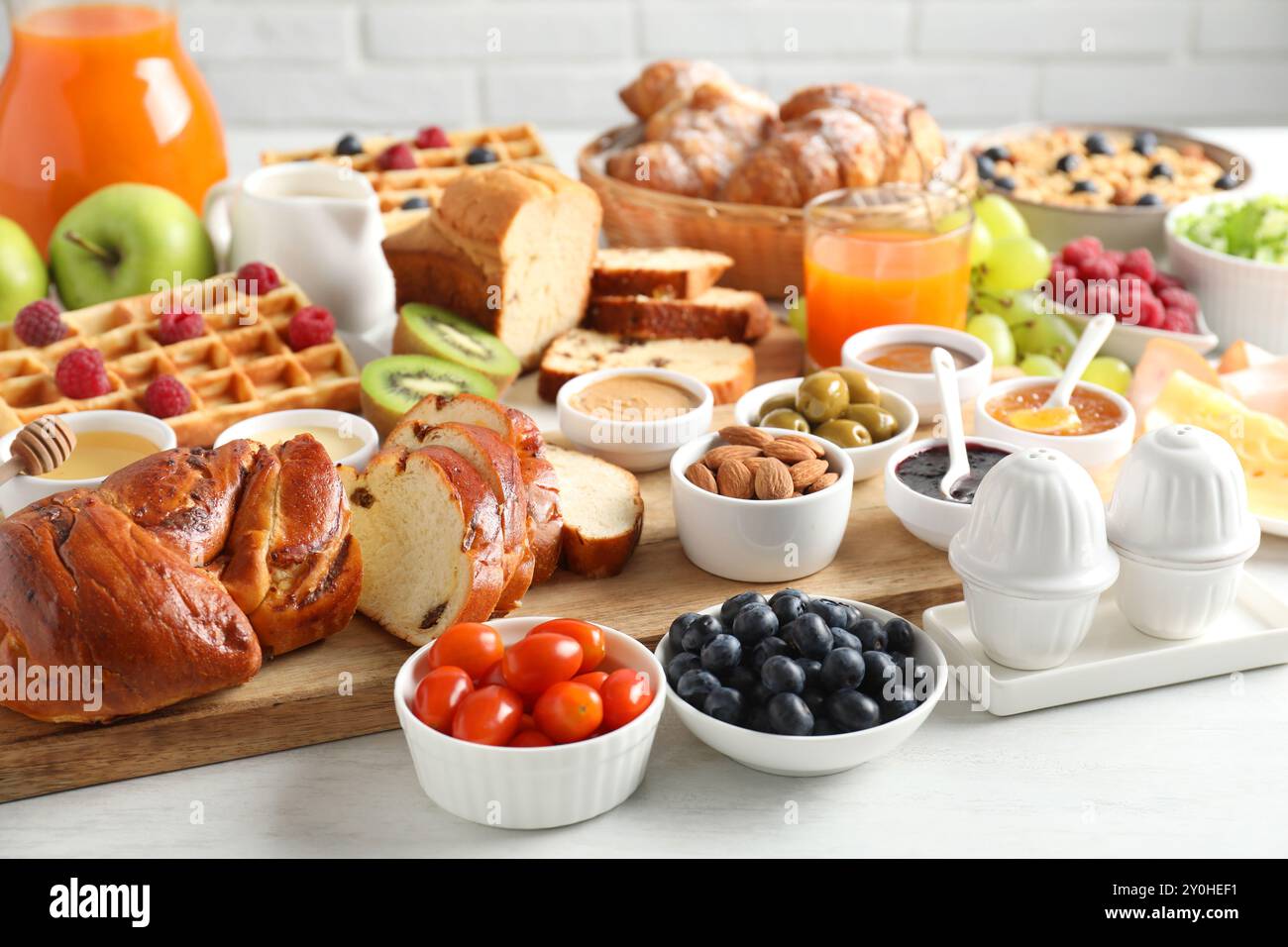 Different meals served for breakfast on white table Stock Photo - Alamy