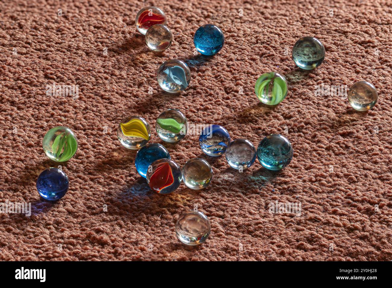 Assortment of colorful glass marbles on a textured background ...