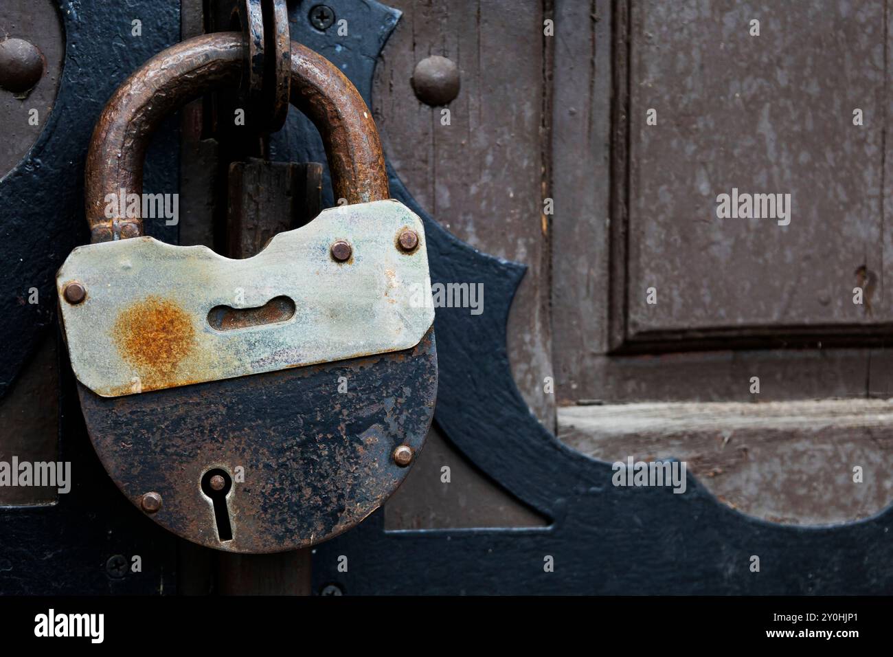 A weathered and rusty padlock featuring a keyhole positioned ...