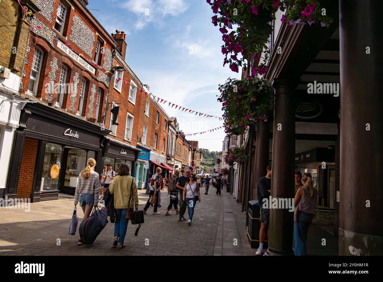 A busy shopping street with people walking and carrying bags ...