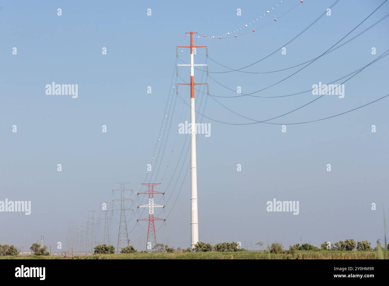 Tall power lines crossing the landscape, carrying electricity over long ...