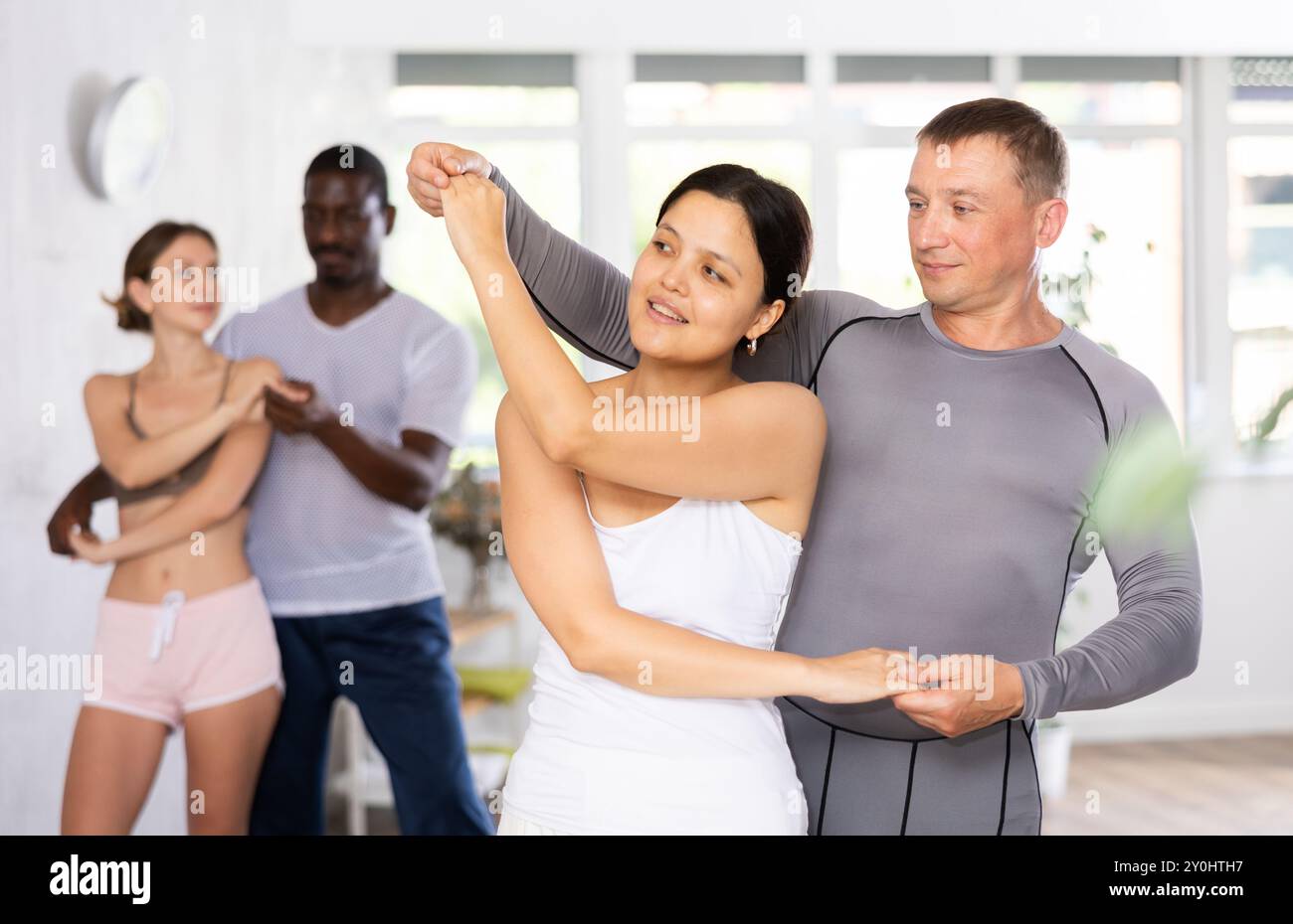 Group of multiethnic active people dancing social dance movements in ...